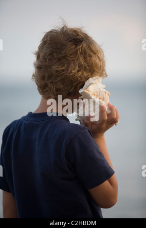 boy listening to seashell Stock Photo - Alamy