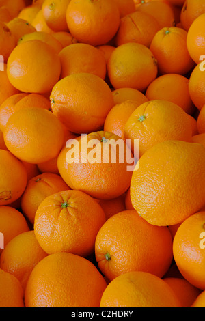 A pile of bright, fresh oranges stacked together, displaying vibrant ...