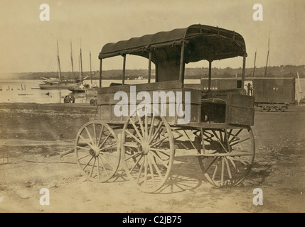 Covered wagon with side curtains rolled up at a military facility ...