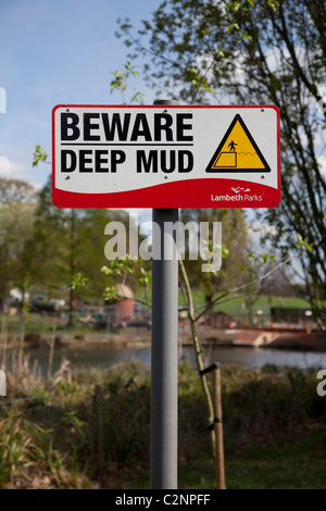 Pond warning signs in a park on a wooden post advising of deep water ...