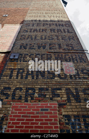 Old, painted-brick signage on boarded-up building seen through Stock ...