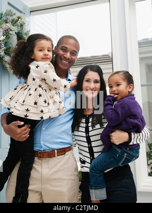 Proud happy hispanic parents posing with little cute girl wearing pink ...