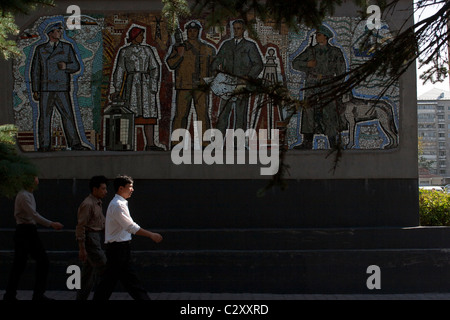 People walk by a Soviet era mural showing people of different ...