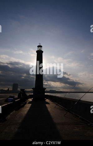 A silhouette of the lighthouse on Margate pier on a cloudy day in ...