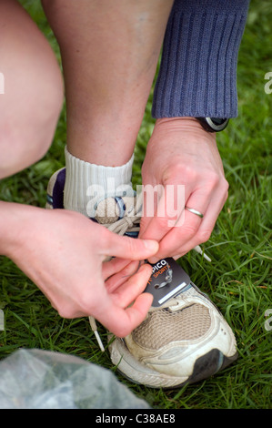 pinning on electronic timing tag to running shoe Stock Photo - Alamy