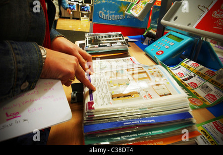 Customer browsing Argos catalogue in store, Farnham, Surrey, UK Stock ...