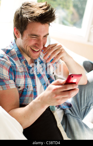 Happy man with mobile phone on beige background with space for text ...