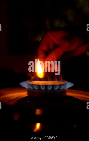 a man lighting a gas cooker ring by match Stock Photo - Alamy