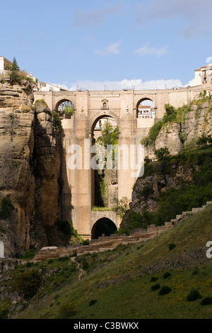 An ancient stone arched bridge spans across calm river waters ...