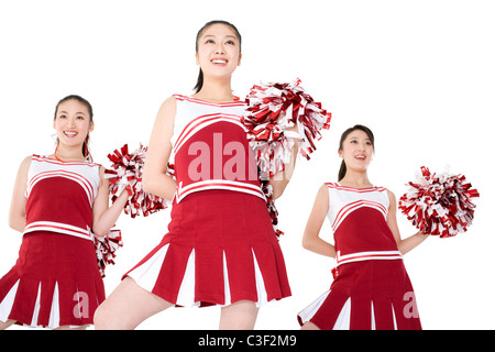 Low angle shot of a smiling cheerleader kneeling on one knee and ...