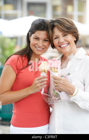 Hispanic mother and daughter holding bouquet of white flowers pointing ...