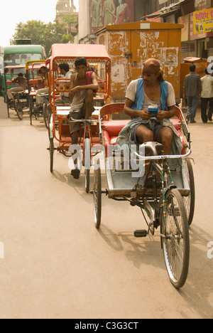 Indian rickshaw puller sitting on his rickshaw and waiting for ...