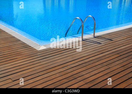 blue swimming pool with teak wood flooring stripes summer vacation ...