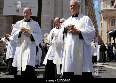 Priests giving out holy communion to faithful in Saint Peter's square ...