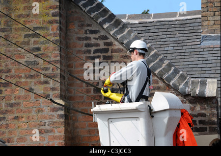 Electrical conractor repalcing old external cables on old house UK ...