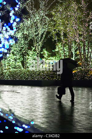 People carry umbrellas while walking on a path overlooking the Golden ...