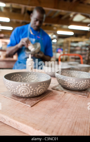 Potter decorates clay pottery at Earthworks pottery workshop studio ...