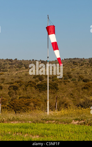 Red and white windsock at an airport, showing wind direction and ...