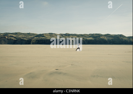 A man running across the empty beach at Hayle, Cornwall Stock Photo - Alamy