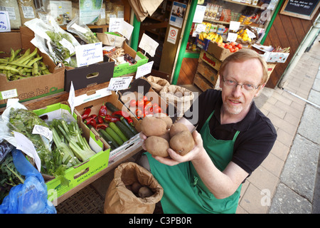 Shopkeeper outside his organic wholefoods shop in Totnes, Devon , UK ...
