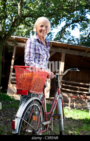 Germany, Saxony, Senior woman with bicycle at the farm Stock Photo - Alamy