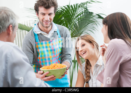 Happy group of friends eating spaghetti pasta with red tomato sauce at ...