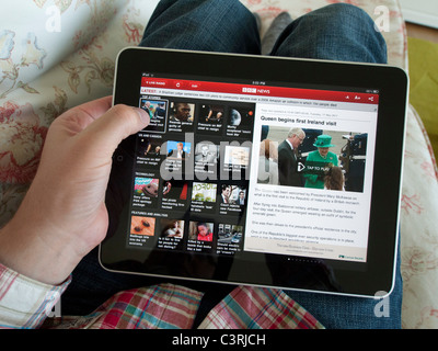 Man reading digital app edition of CNN news on an iPad touch screen ...