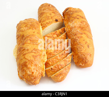 The ruddy long loaf of bread is strewed by cheese isolated on a white ...