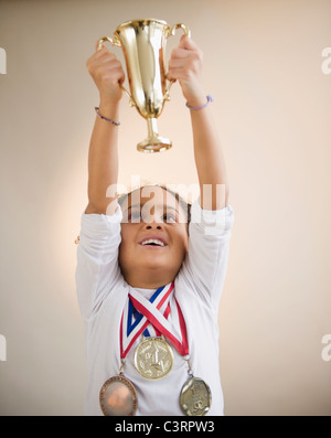 Girl lifting trophy portrait Stock Photo - Alamy
