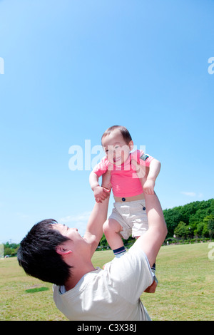 Man holding a baby boy aloft, both smiling Stock Photo - Alamy