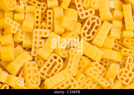 Background of pasta shaped alphabet letters in a tomato sauce Stock ...