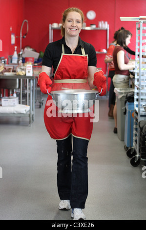 Happy woman chef with colander in hand on studio background, mockup ...
