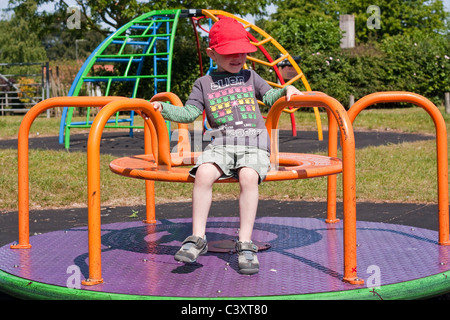 Young boy on playground roundabout with a red tint Stock Photo: 6822378 ...