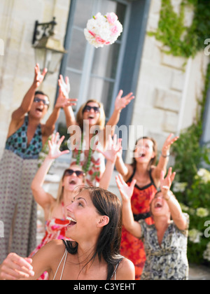 Wedding bouquet throwing, the newlywed bride is throwing the flowers to ...