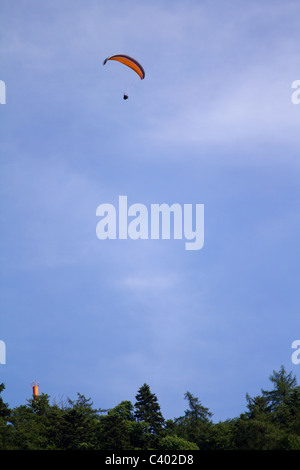 Orange paragliding sail with a blue sky background with copy space ...