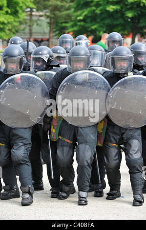 Riot squad police officers forming a protective barrier with riot ...