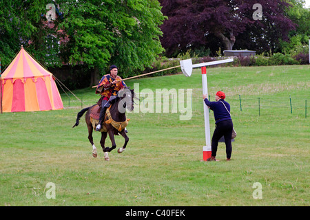 A knight practices tilting at a quintain at a medieval reenactment ...