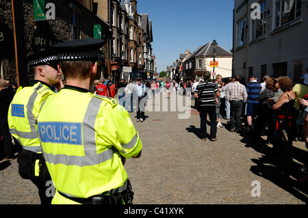 Policemen control crowd in town high street with high visibility vests ...