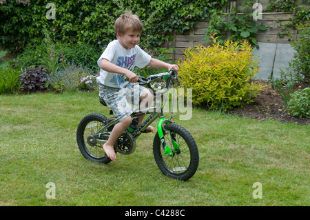 happy boy learning to ride his first bike Stock Photo - Alamy