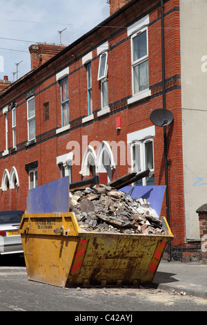 Home renovation. Full skip outside a house being renovated, England, UK ...