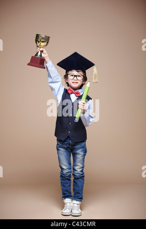 boy pick up the trophy wearing graduation cap Stock Photo - Alamy