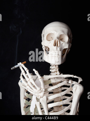 A vertical shot of a skeleton with a cigarette - smoking kills concept ...