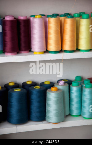 A row of multi-colored thread spools in brown orange yellow tones Stock ...