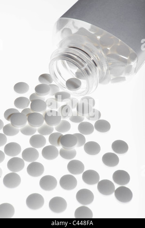 Pills spilling from an open bottle isolated on pink background Stock ...