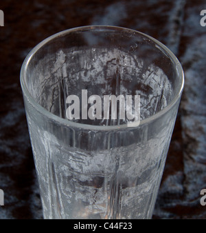 Drinking glass showing lime scale damage Stock Photo - Alamy