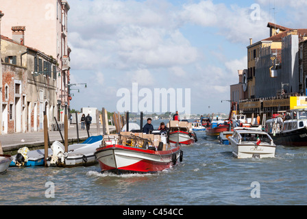 Workboats navigate a busy canal in Venice, Italy Stock Photo - Alamy