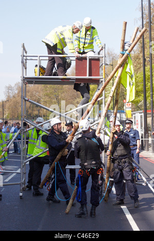 Protesters sit on top of tripods outside the London office of EDF ...
