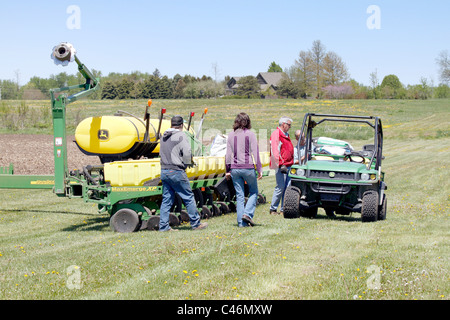 Workers prepare for sowing a seed demonstration plot. This involves ...