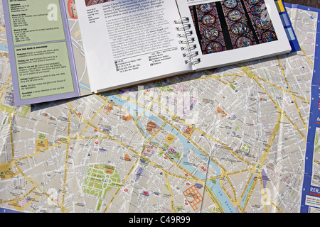 A tourist map of Paris, France with an open guidebook Stock Photo - Alamy