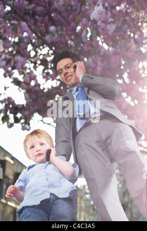 Dad walking with his baby while use his mobile phone Stock Photo - Alamy